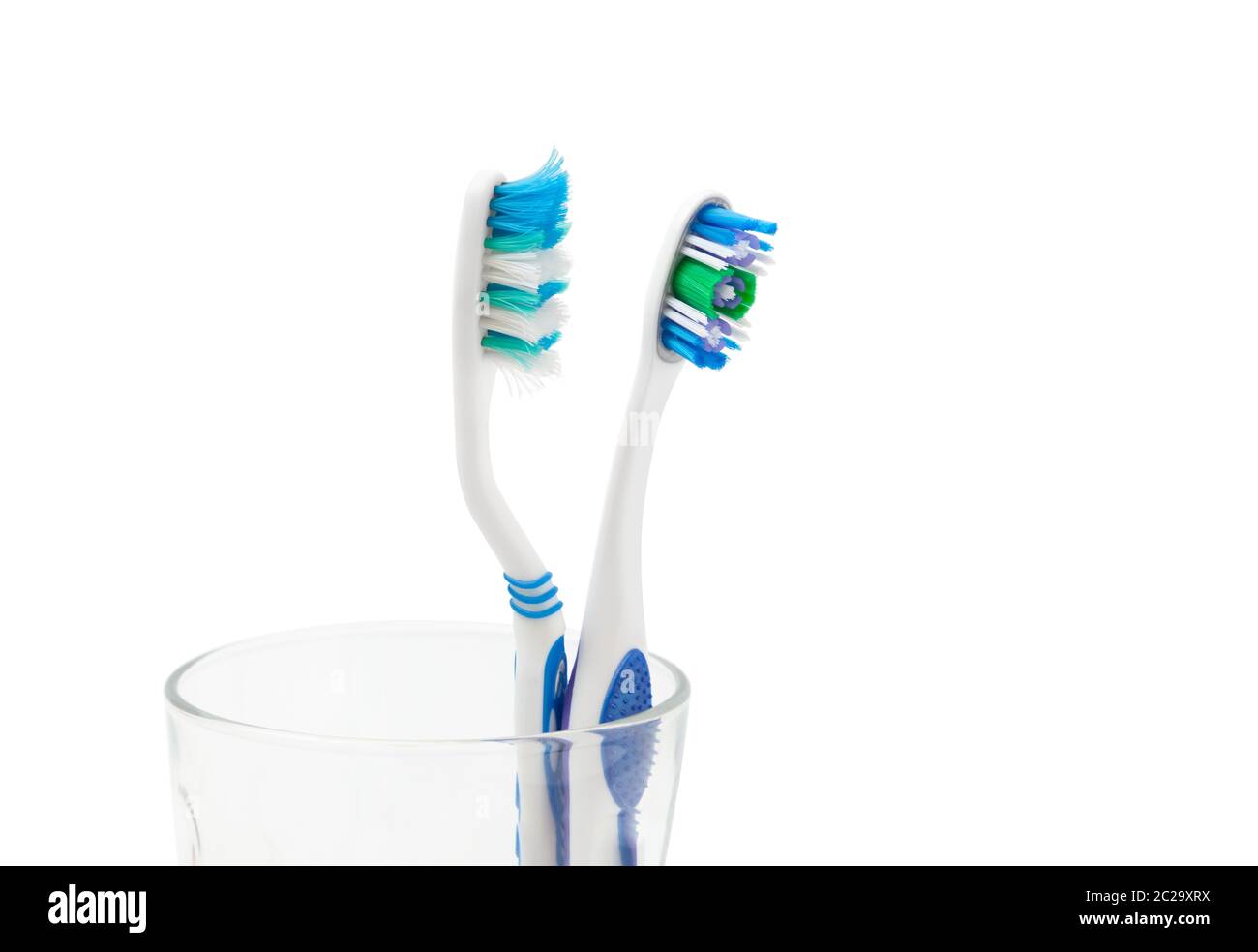 New toothbrush and old toothbrush (damaged) in clear glass for teeth ...