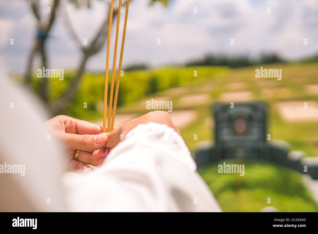 close-up of a woman hand holding incense. The background is an ...