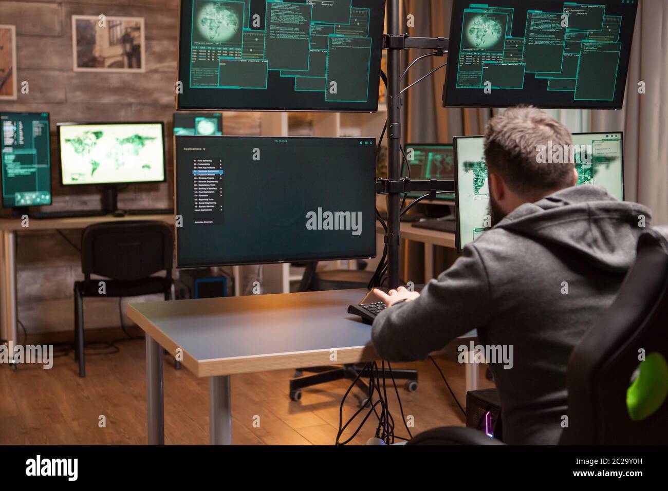 Shot from the back of dangerous hacker making a dangerous virus ...