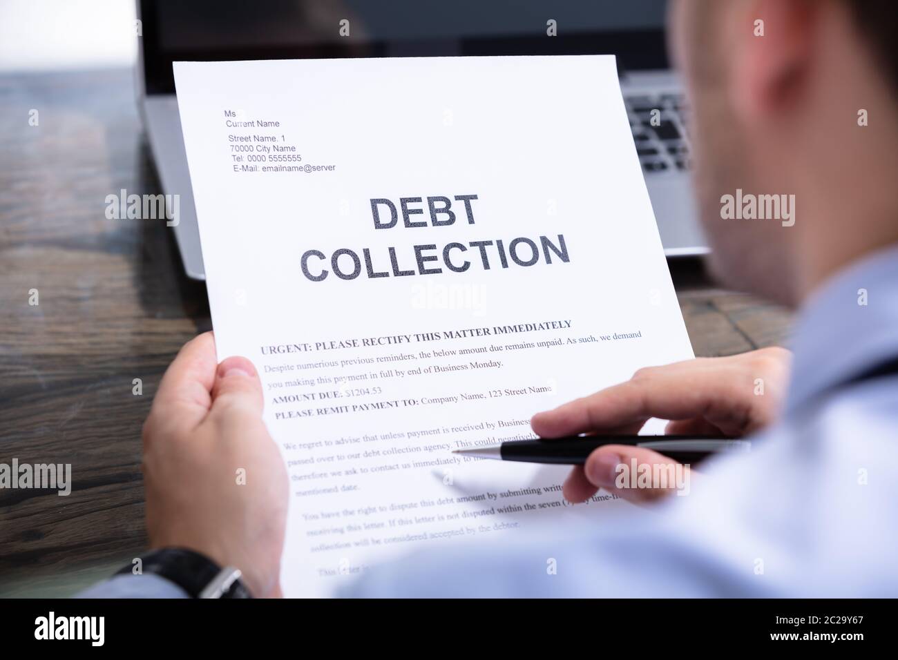 Man Reading Debt Collection Notice Letter At Desk Stock Photo - Alamy