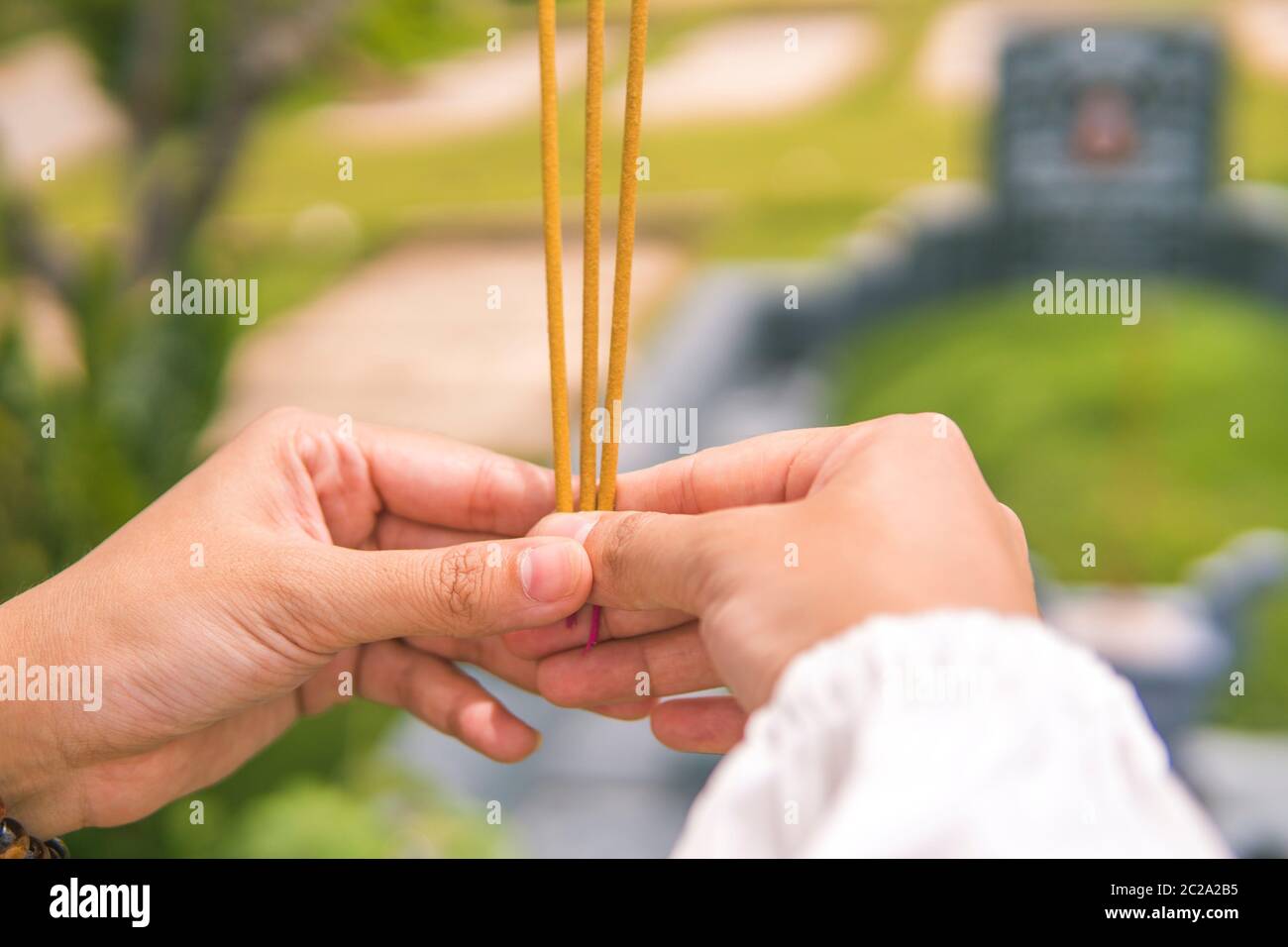 close-up of a woman hand holding incense. The background is an ...