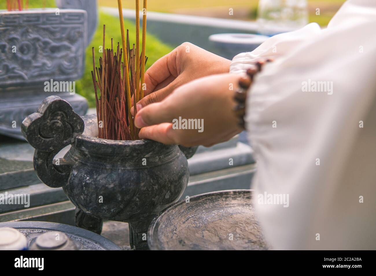 close-up of a woman hand holding incense. The background is an ...
