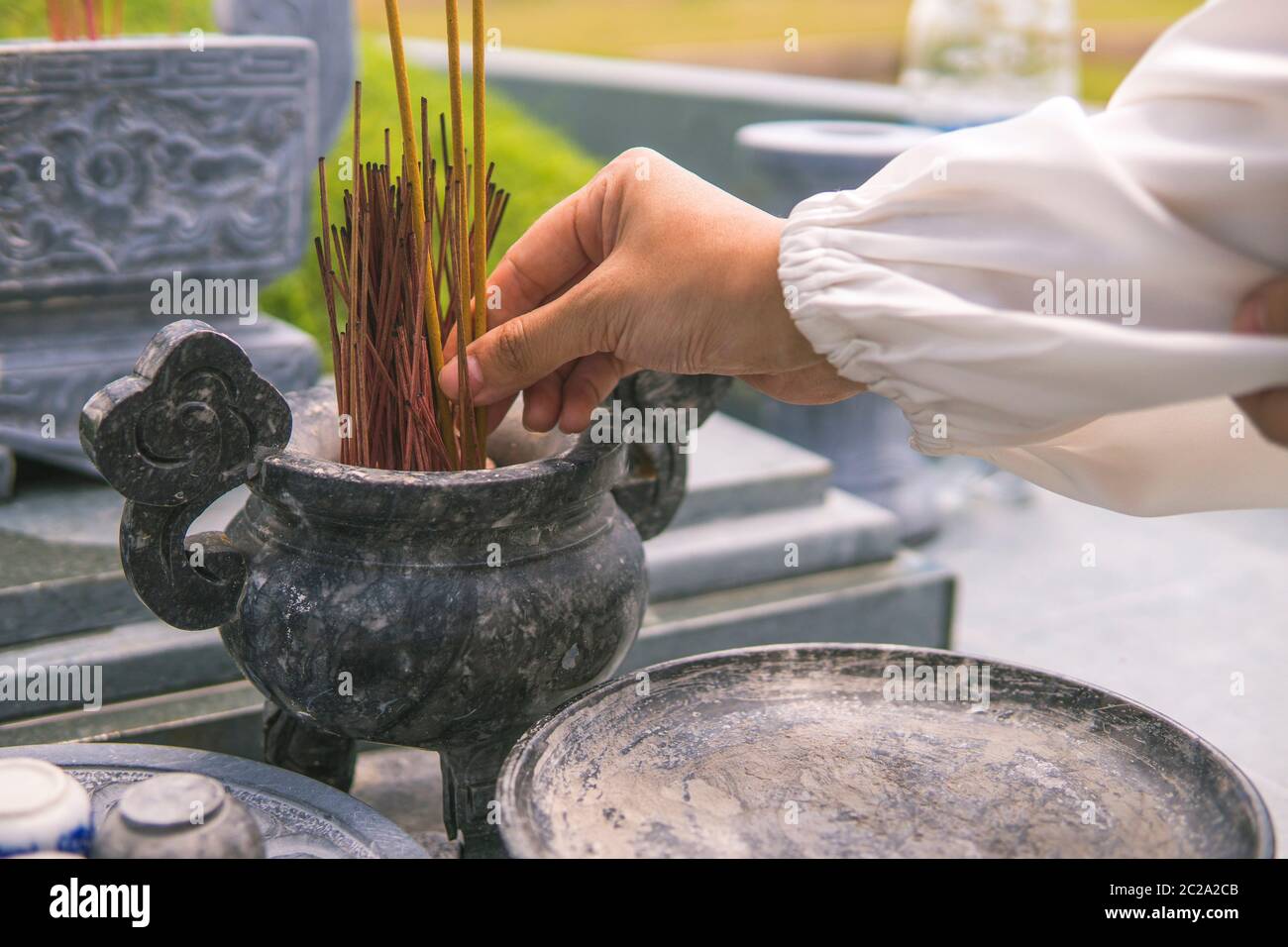 close-up of a woman hand holding incense. The background is an ...