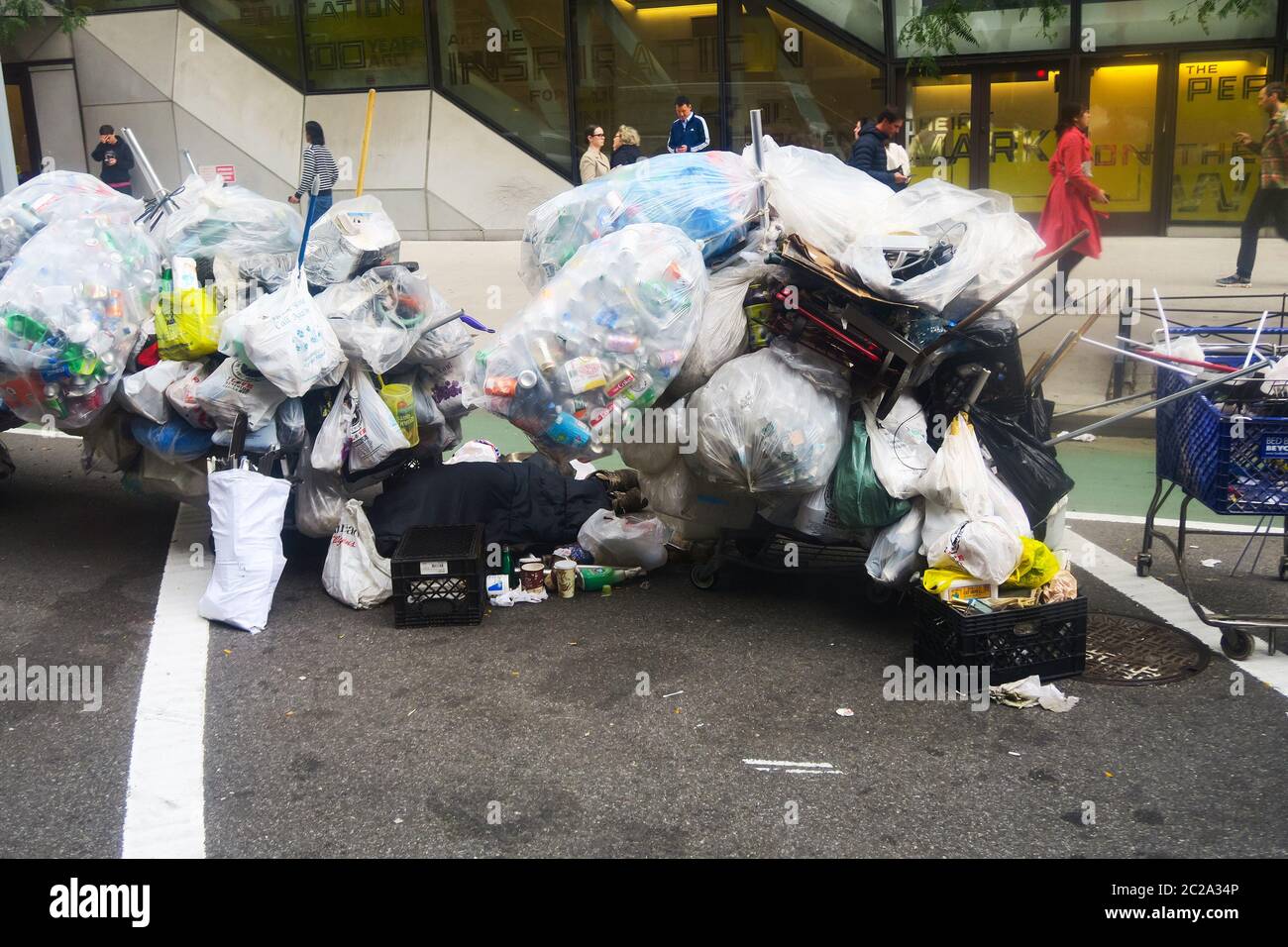 Homeless person in New York sleeping under recycling Stock Photo - Alamy