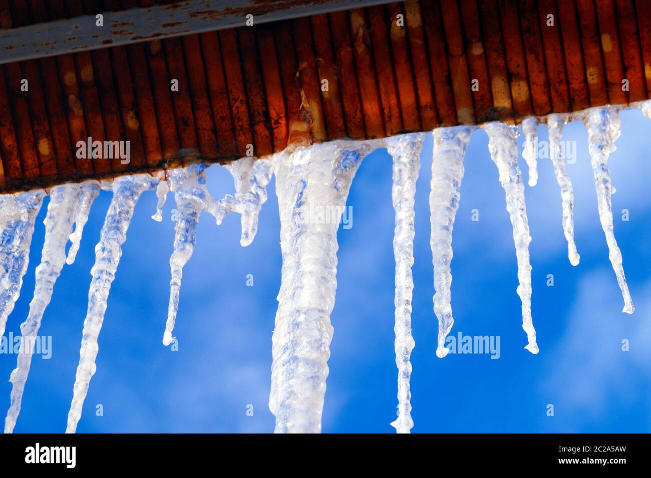 Many large and sharp icicles hang on the roof of the house Stock Photo ...