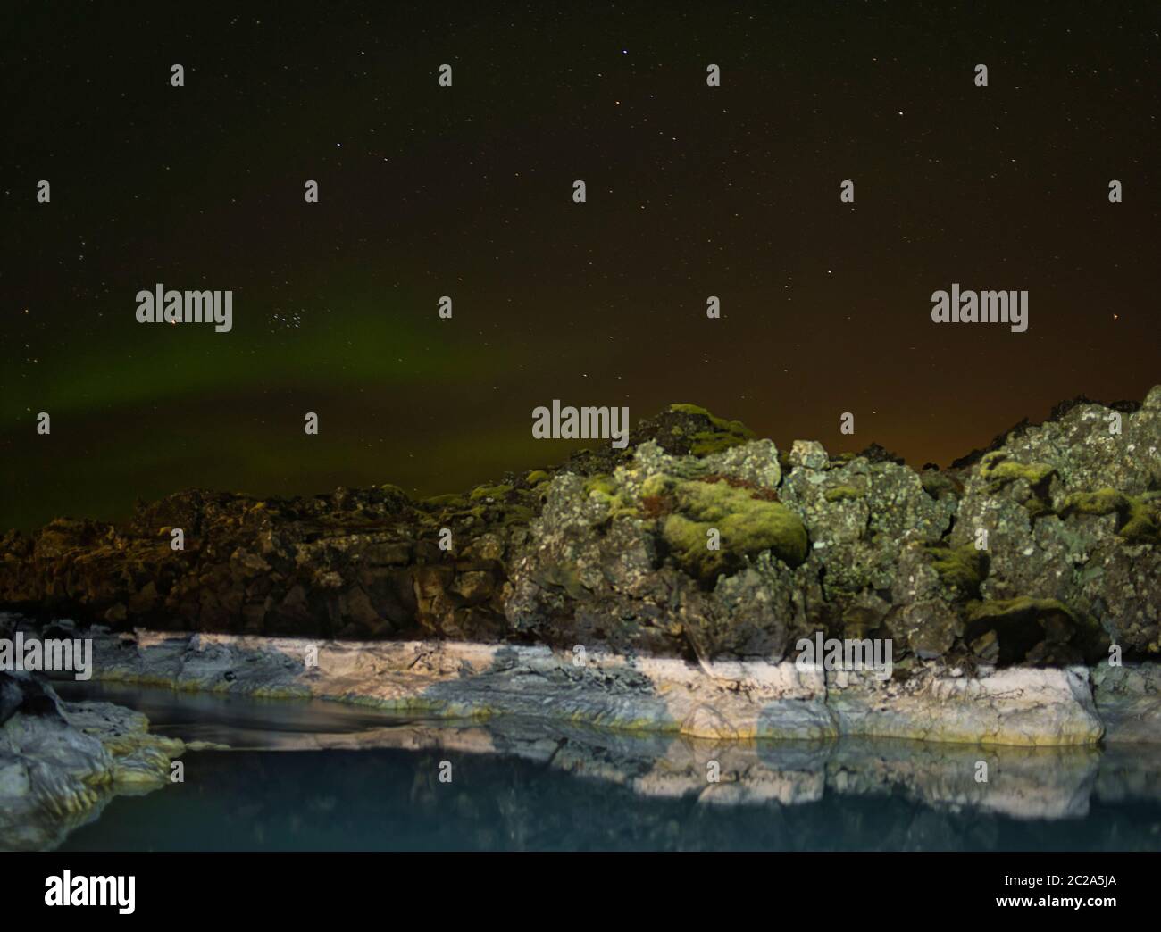 Northern lights and reflecting rocks in thermal water Stock Photo - Alamy