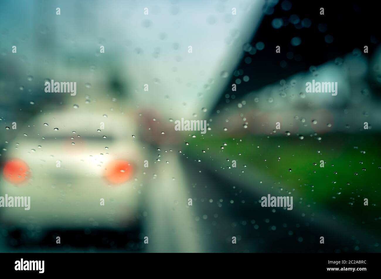 Rain drops on windshield. Car driving on asphalt road on rainy day ...