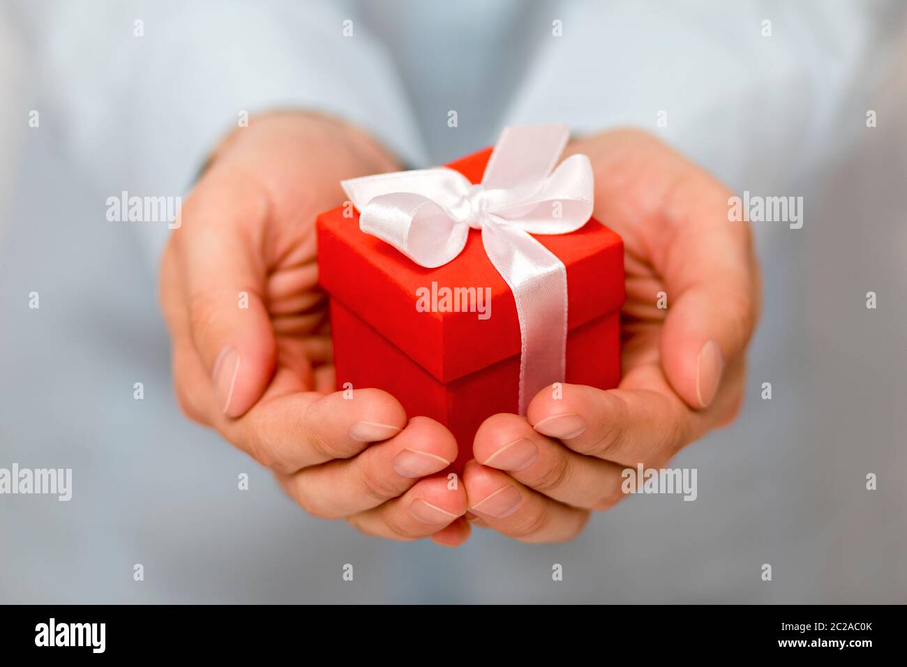 Human hands holding gift box hi-res stock photography and images - Alamy