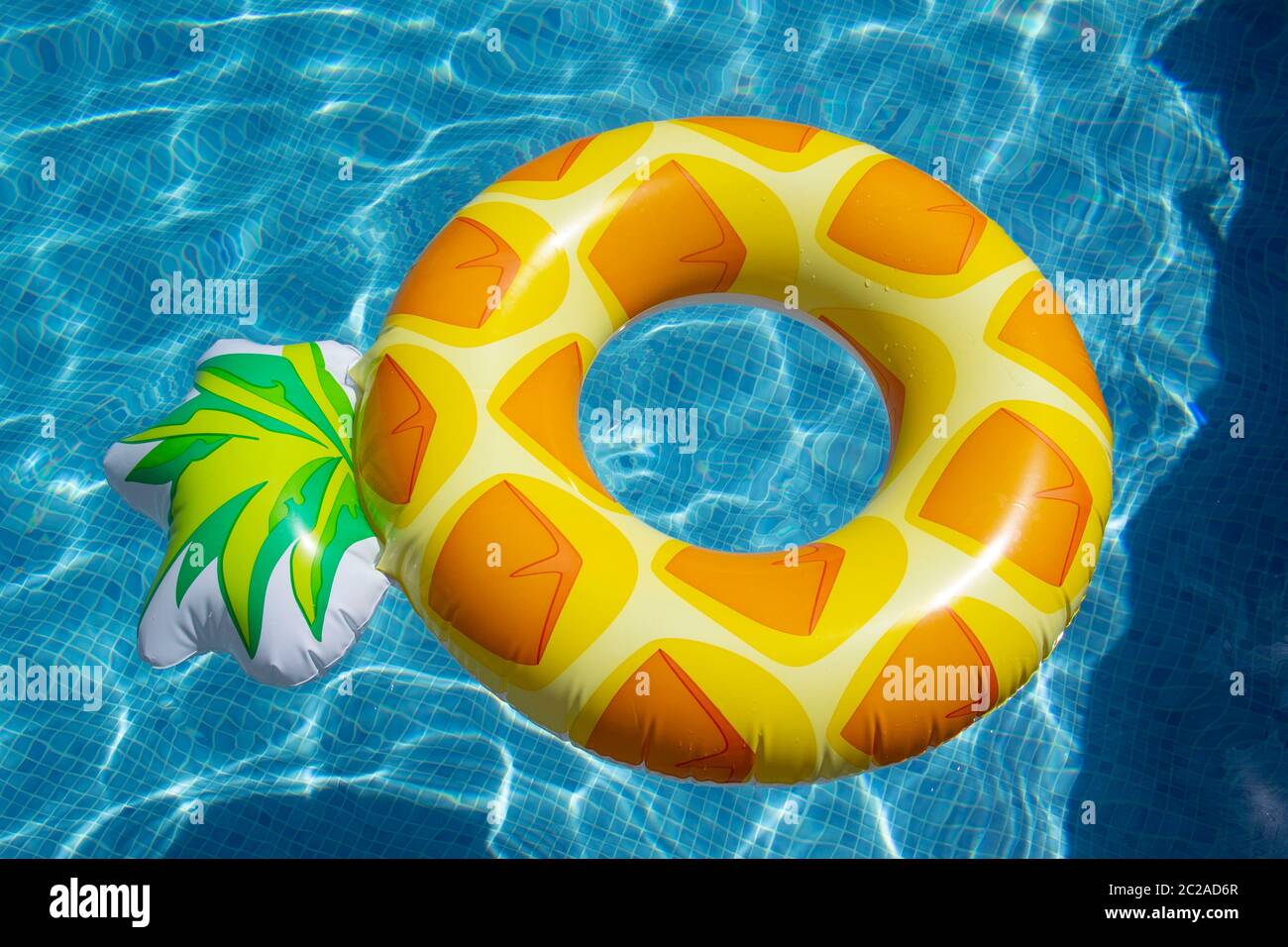 inflatable pineapple ring floating in swimming pool Stock Photo - Alamy