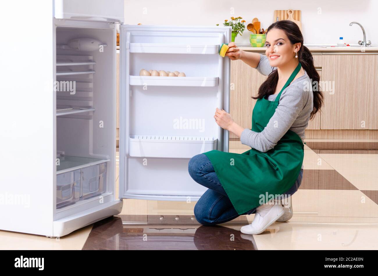 Young woman cleaning fridge in hygiene concept Stock Photo - Alamy