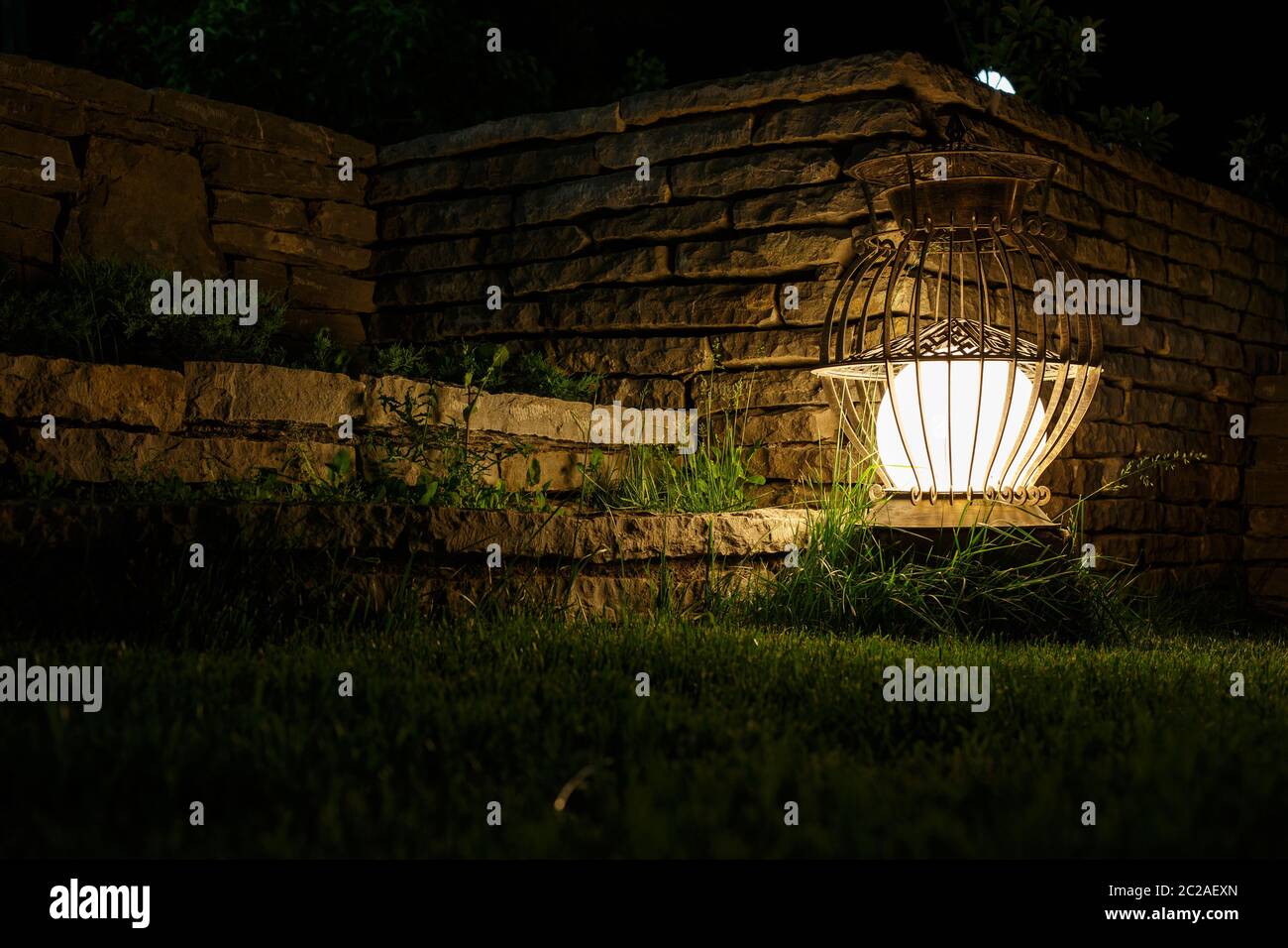 an ancient garden lantern shines in the night . selective focus Stock ...