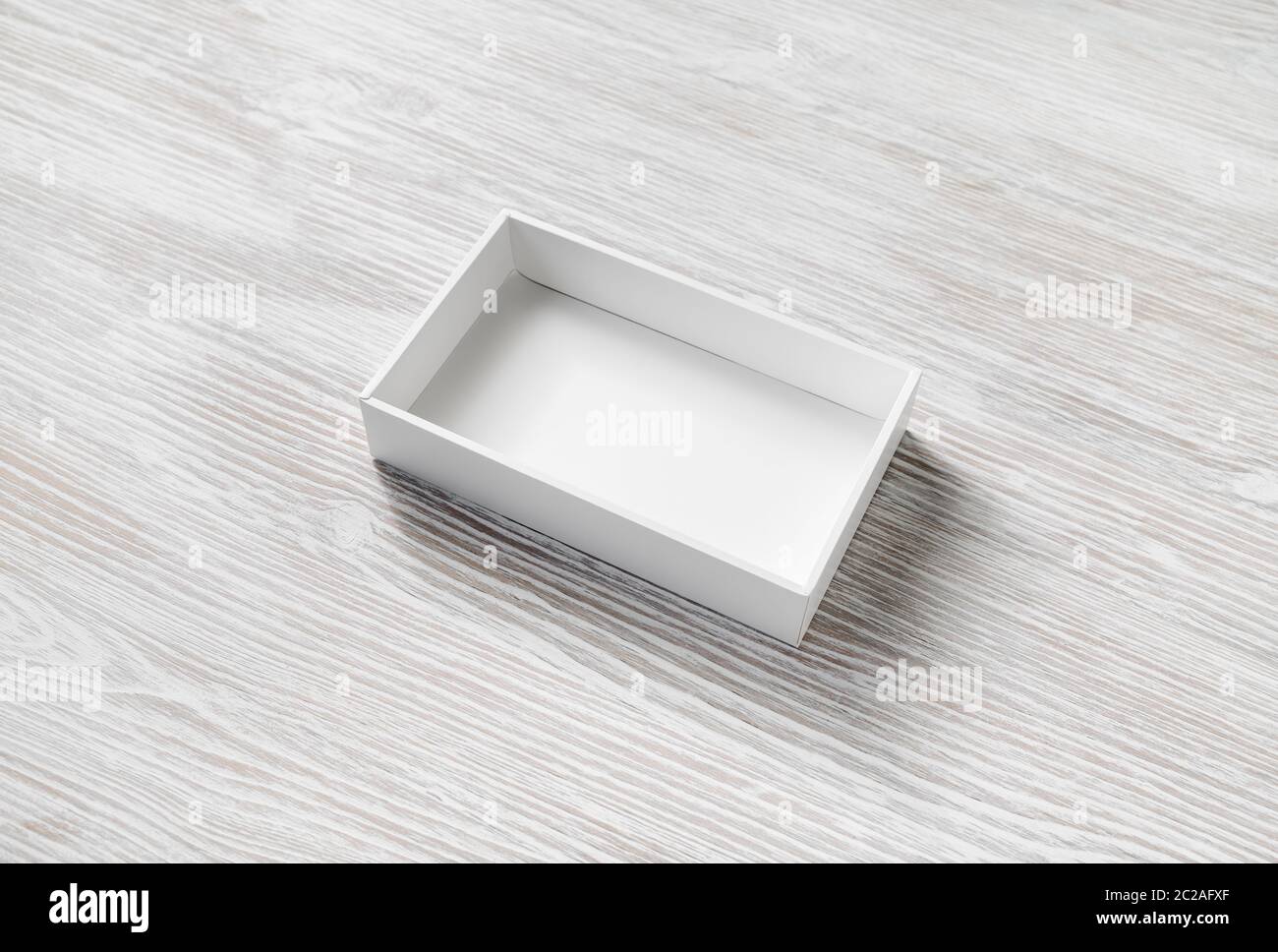 Blank opened box on light wood table background. Responsive design ...
