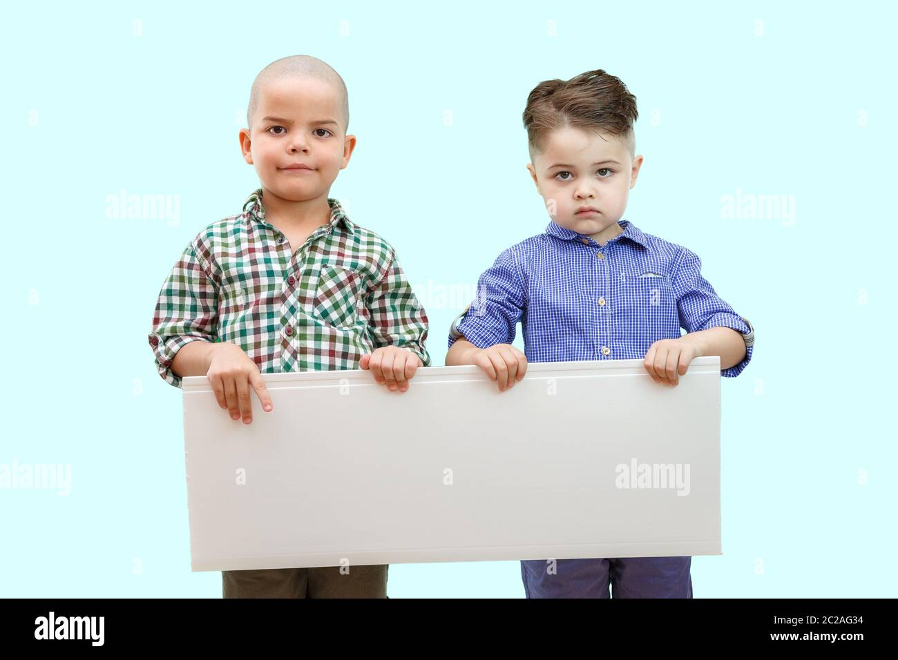 Portrait of two boys holding white sign on isolated background Stock ...