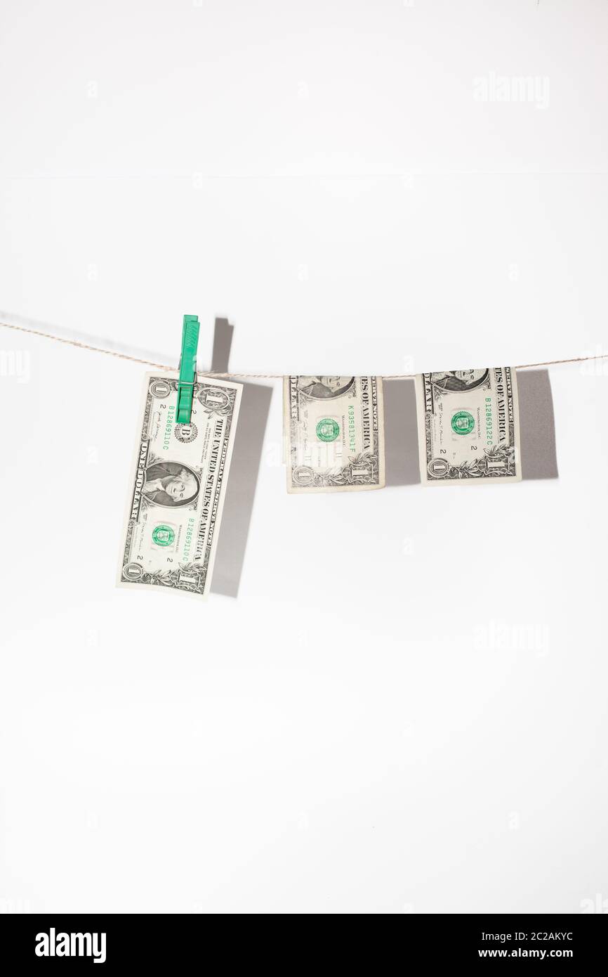 Money laundering - American dollars hanging on a string with pins Stock ...