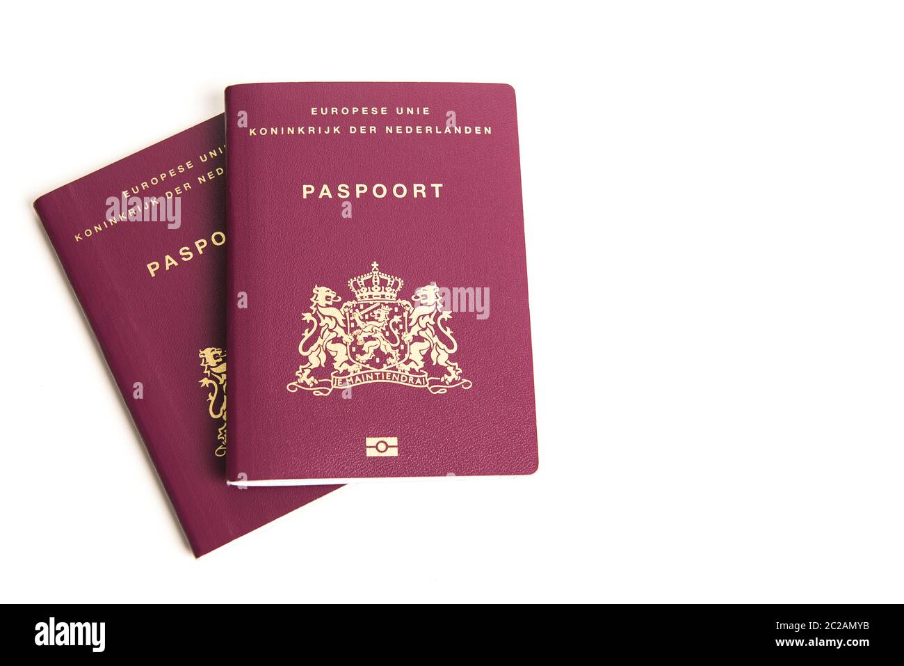Two closed european passports from the Netherlands lying on a white ...
