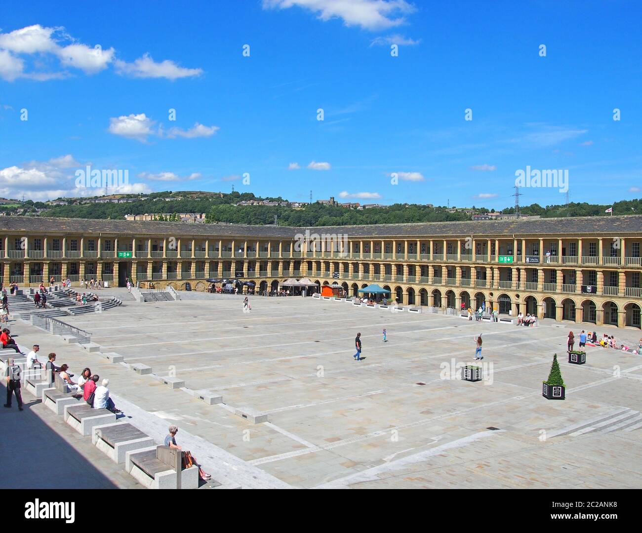 people relaxing on the steps and cafes and walking across the square of ...