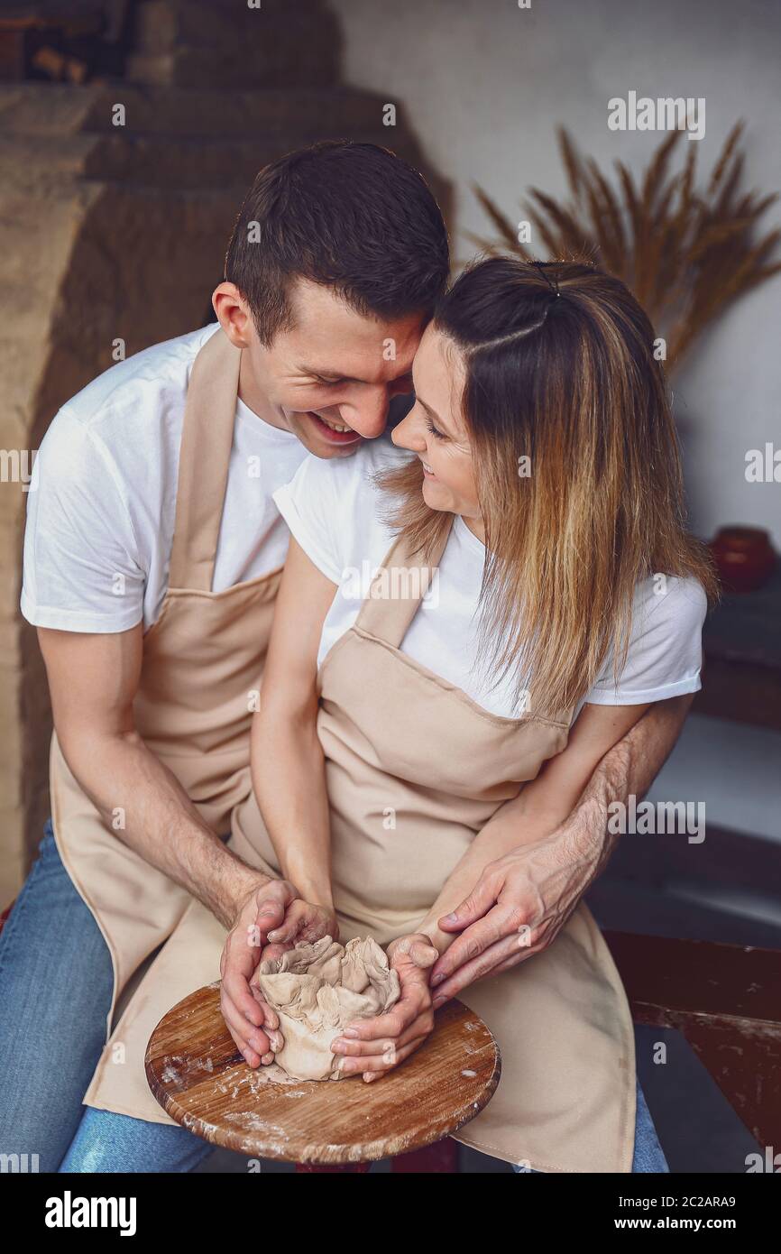 romantic couple in love working together on potter wheel and sculpting ...