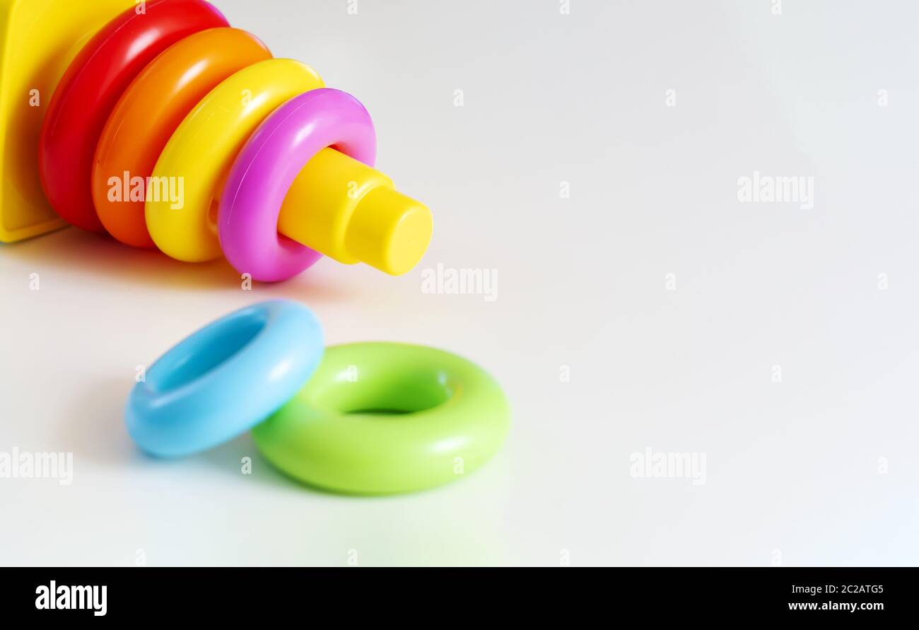 Plastic rings of various colors are stacked in a yellow plastic tower ...