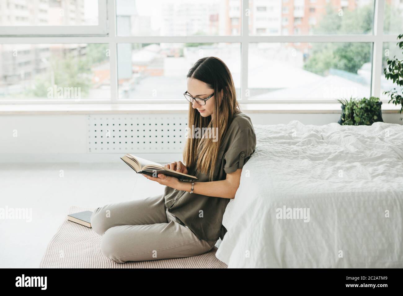 Beautiful girl reading a book at home in a cozy setting Stock Photo - Alamy