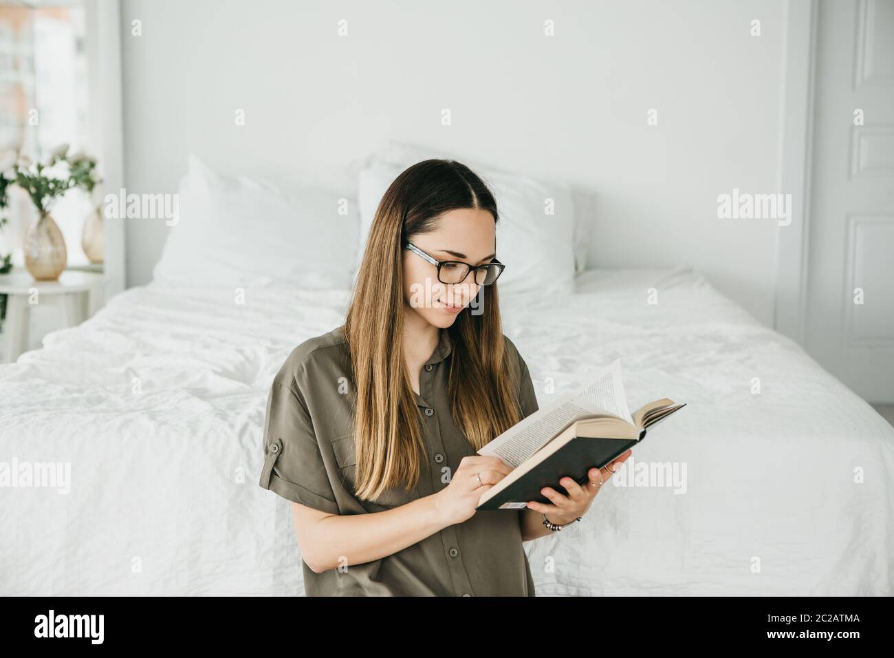 Beautiful girl reading a book at home in a cozy setting Stock Photo - Alamy