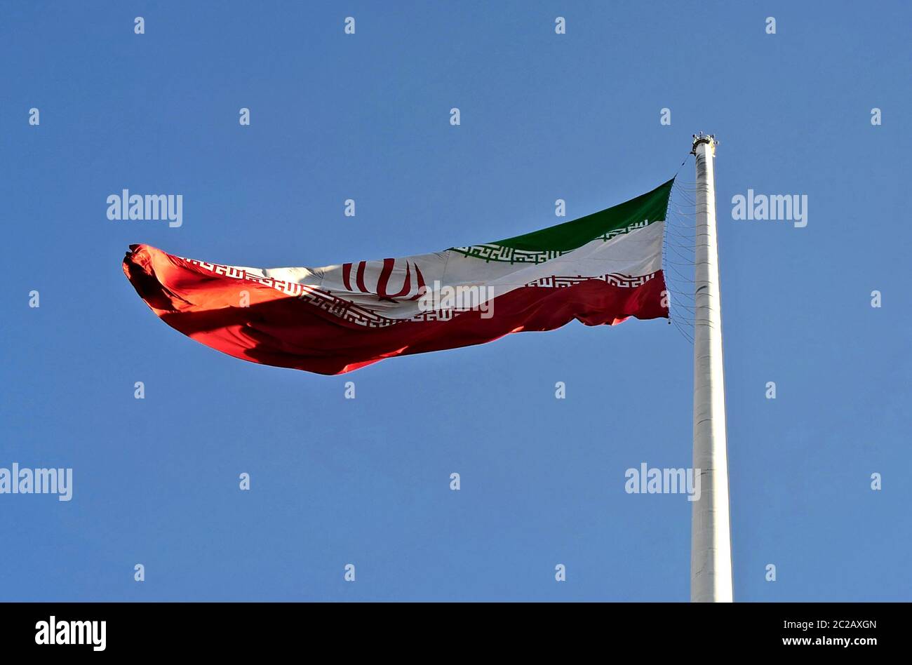 Iranian flag at the Taleghani Park, with blue sky in the background, in ...