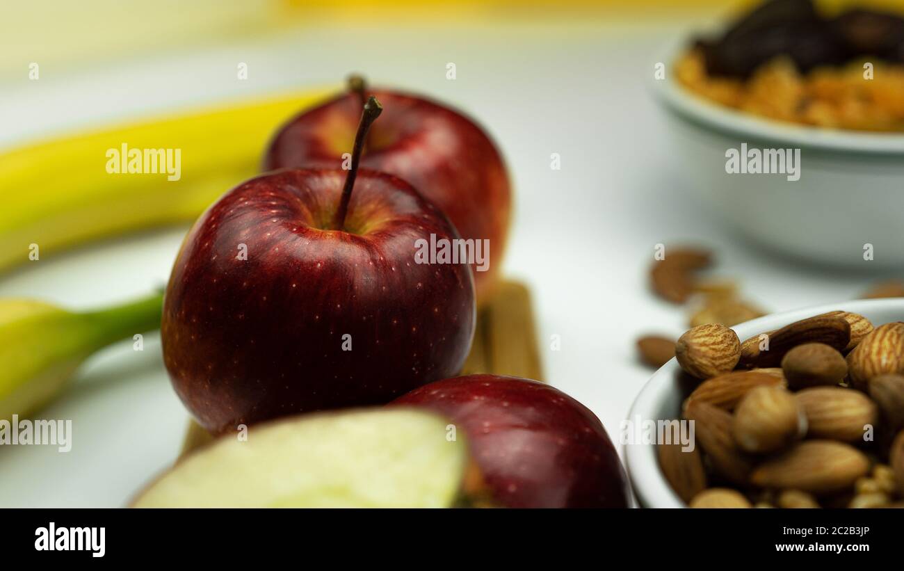An Apple, a tape measure, nuts, and placed on a white background remind ...