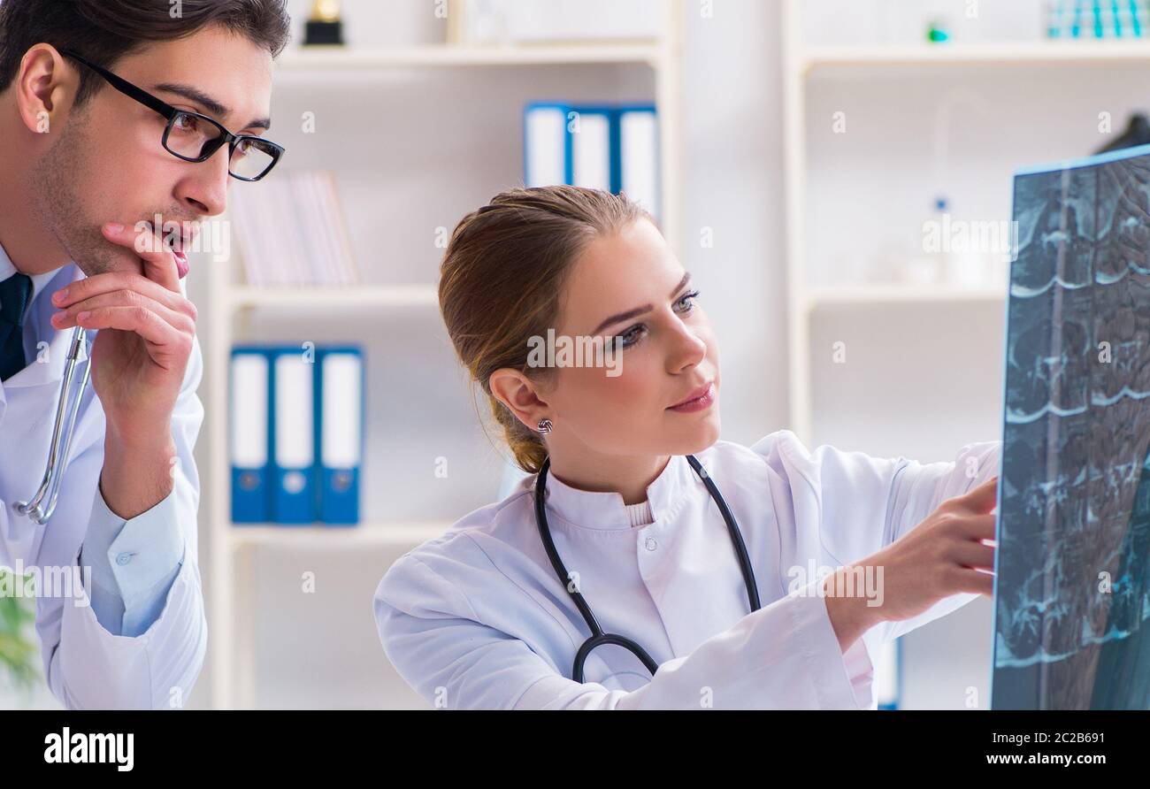 Two doctors examining x-ray images of patient for diagnosis Stock Photo ...