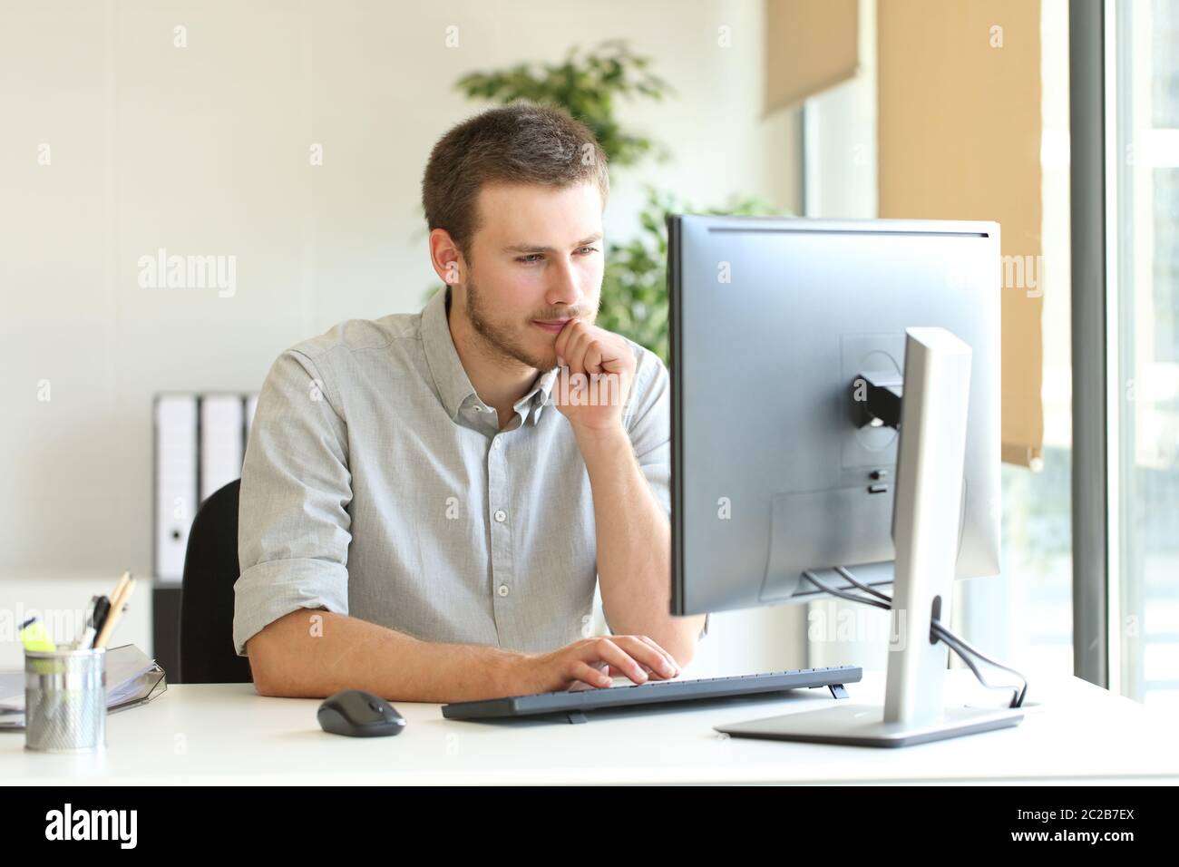 Concentrated businessman using computer watching online content at ...