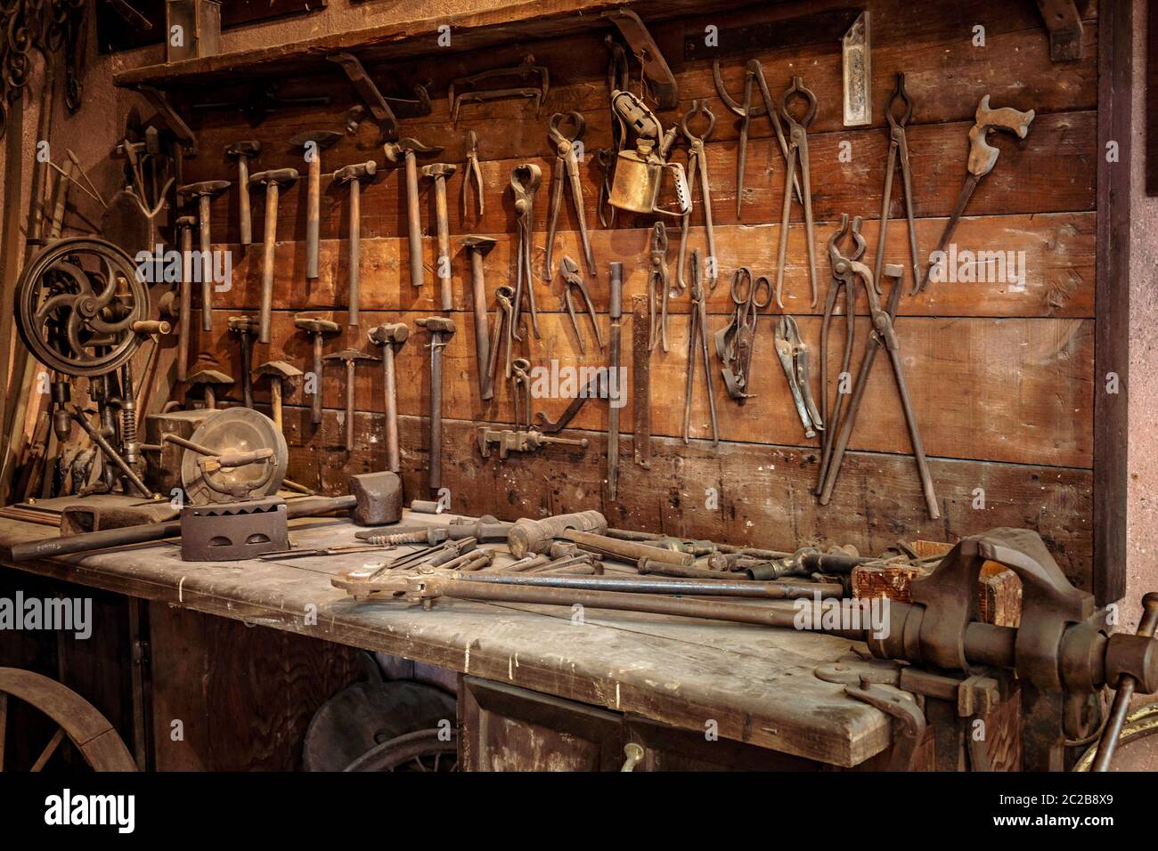 Complete workbench with a wall of tools in a workshop. Vintage look ...