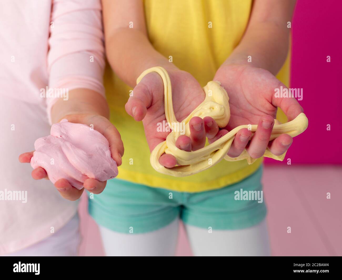 two beautiful girls playing with homemade slime and having a lot of fun ...