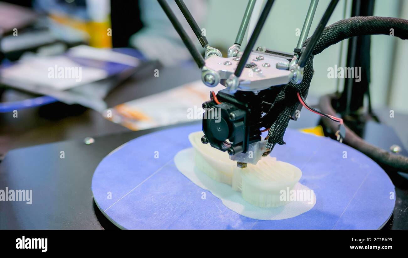 3D printer prints physical 3D model with plastic wire filament at ...
