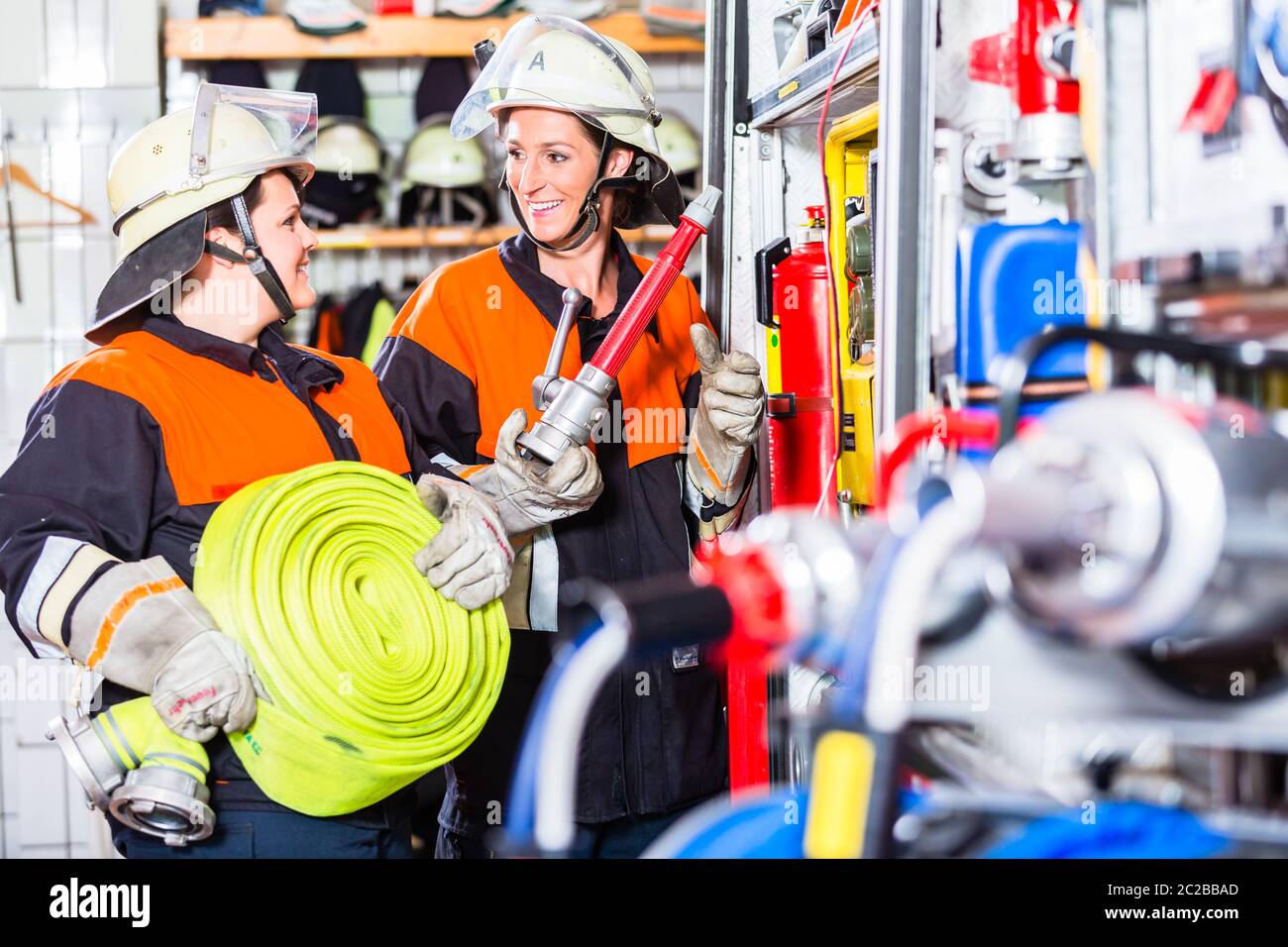 Female fire fighters loading hoses into fire engine Stock Photo - Alamy