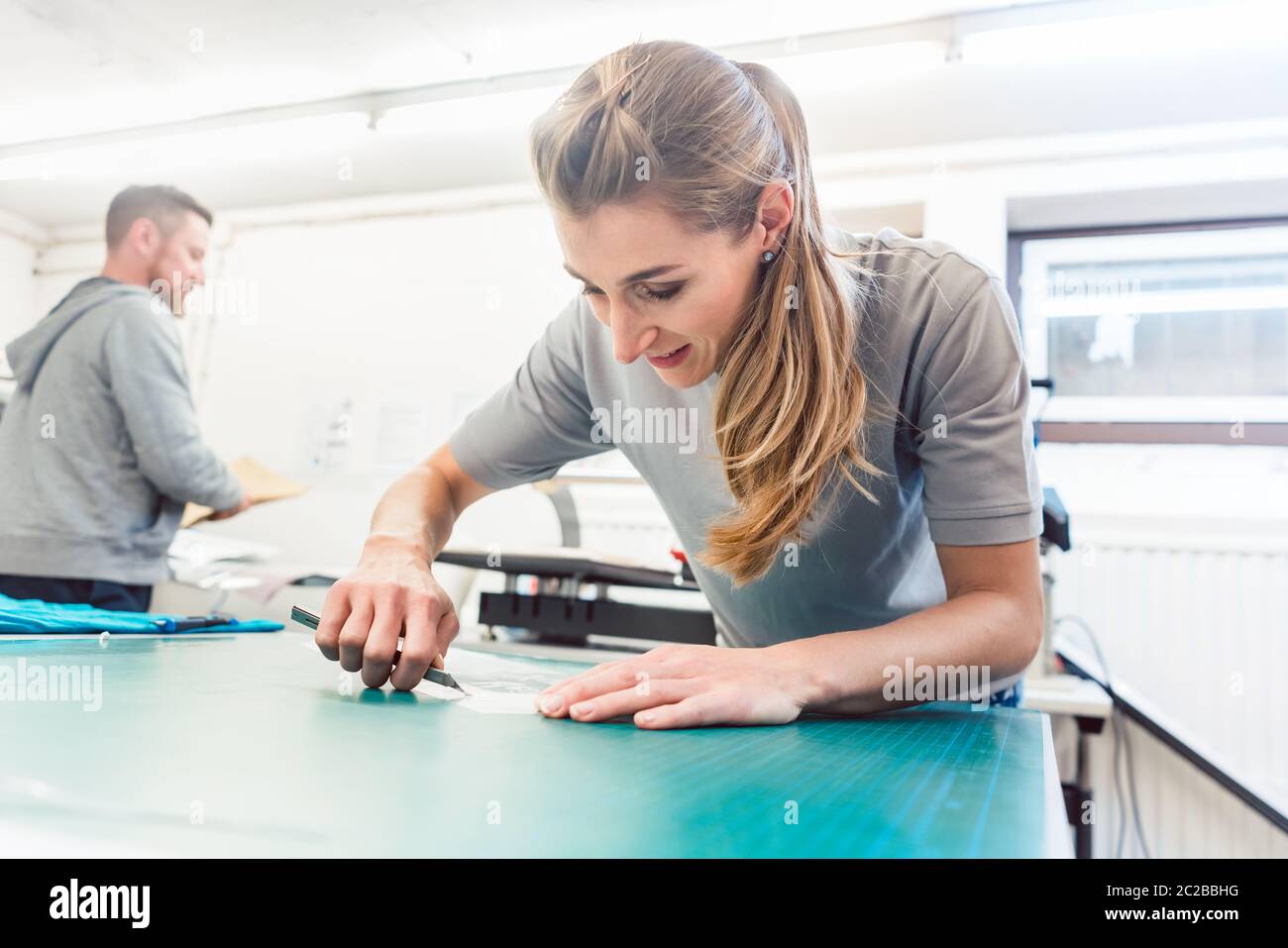 Woman preparing advertisement sticker with text to be printed on a T ...