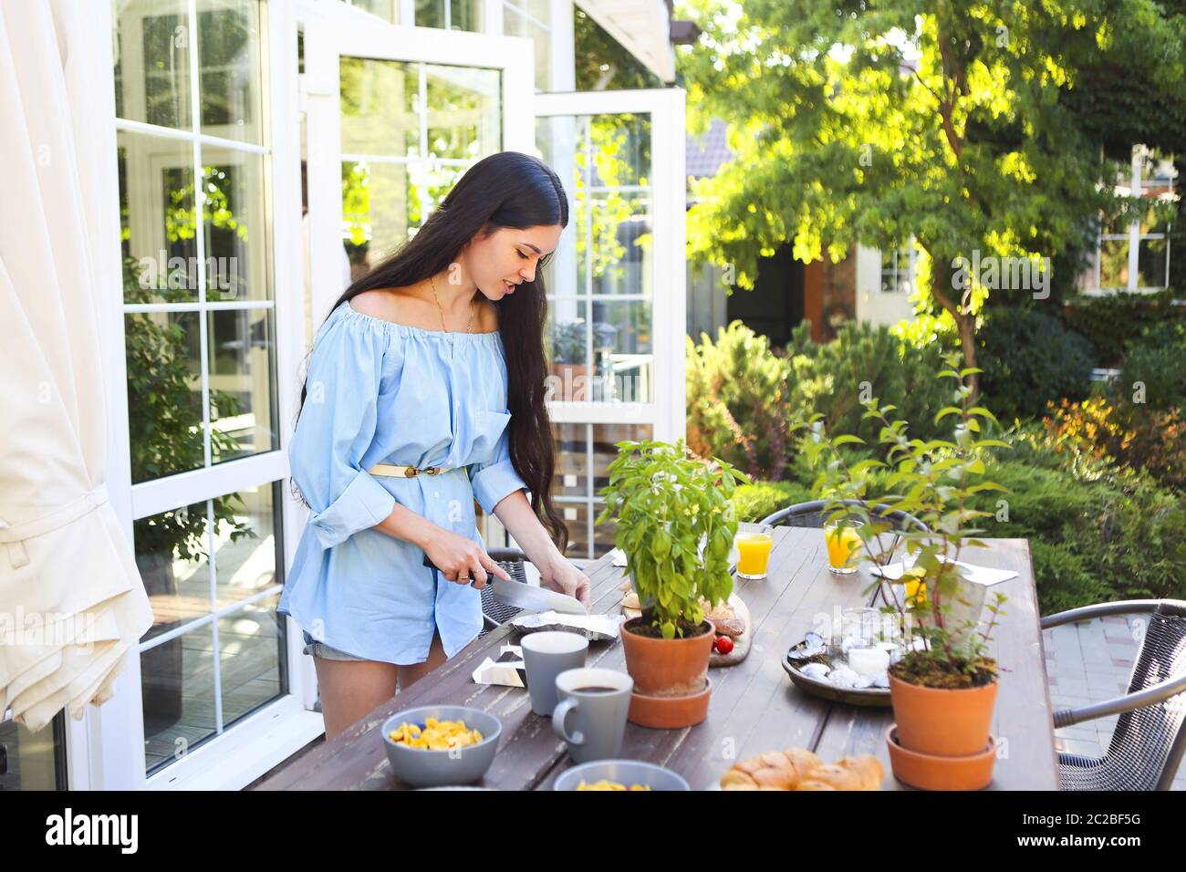 Beautiful young woman cooking dinner at the home in the garden Stock ...