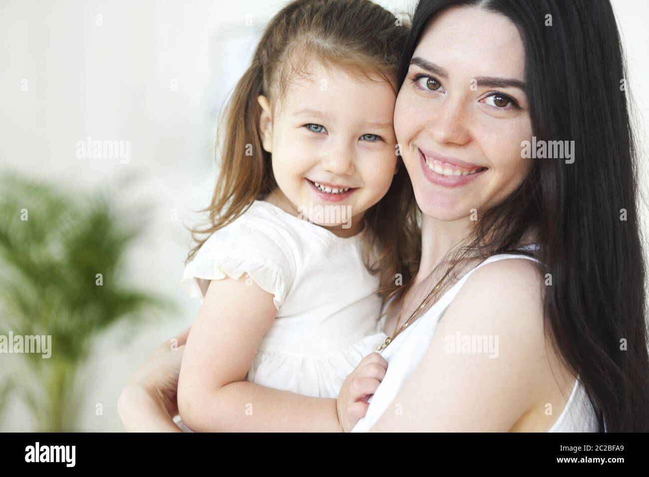 Happy young bright mother hugging her little daughter Stock Photo - Alamy
