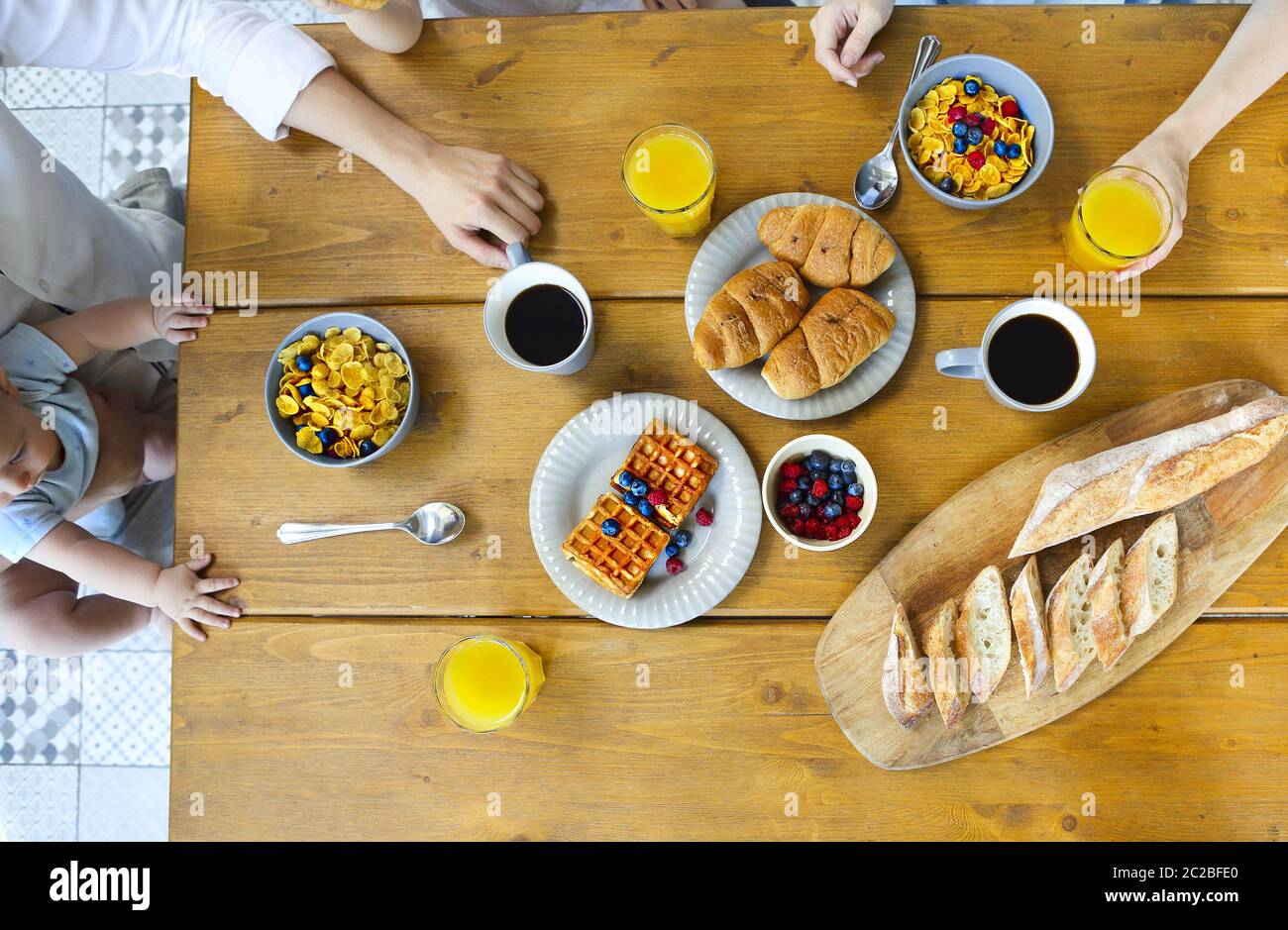 Family of four having breakfast In the kitchen Stock Photo - Alamy
