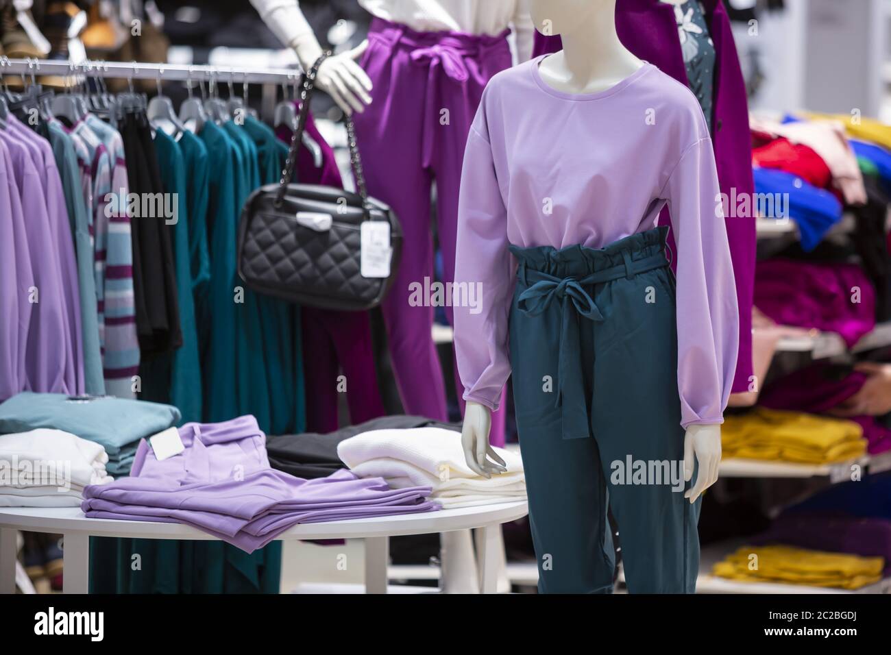 Mannequin and clothes of different colors on hangers Stock Photo - Alamy