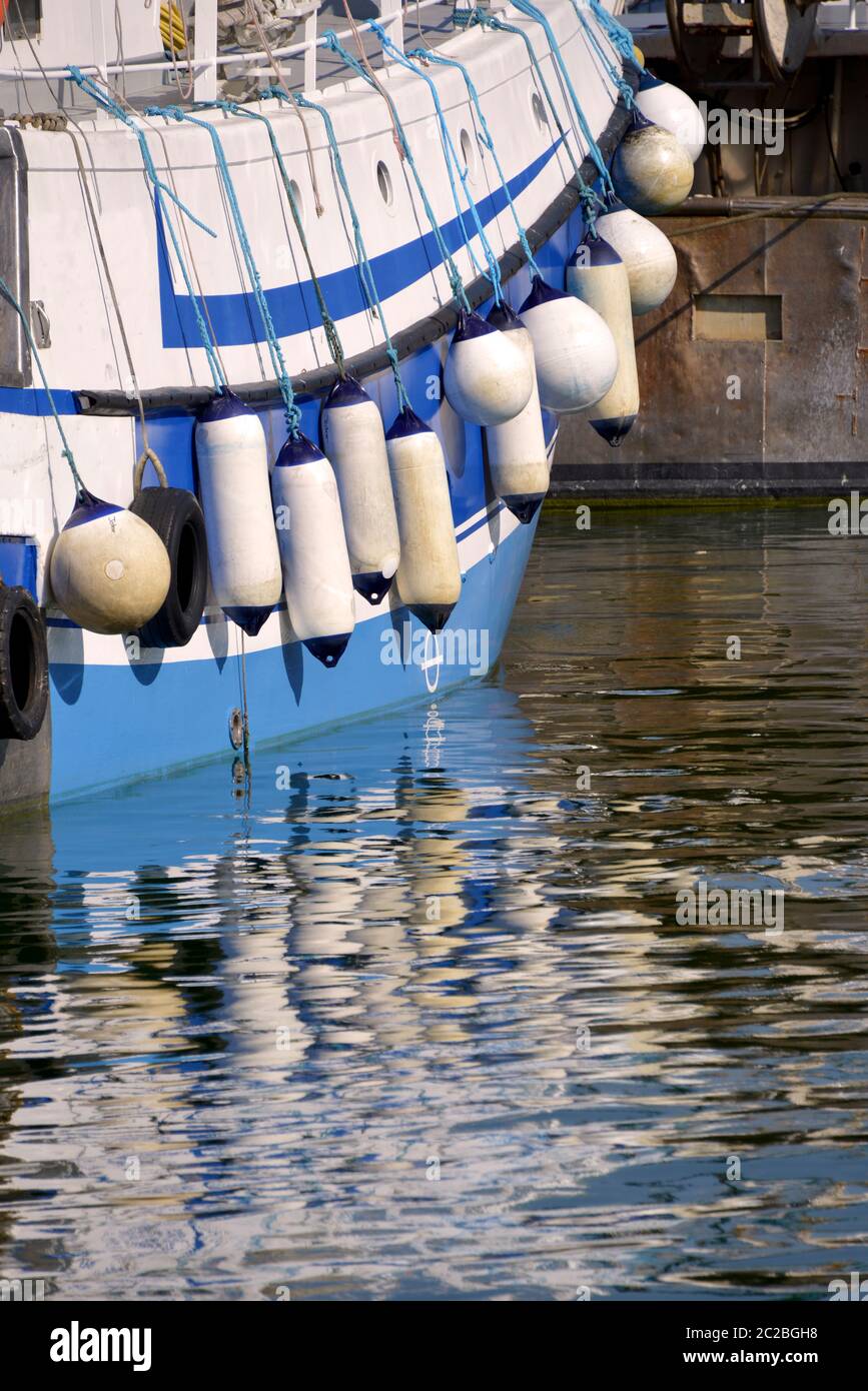 Reflection of fishing boats with buoys in blue sea Stock Photo - Alamy