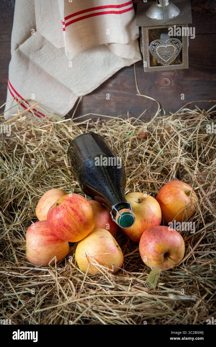 Bottle of cider with organic apples on the straw Stock Photo - Alamy