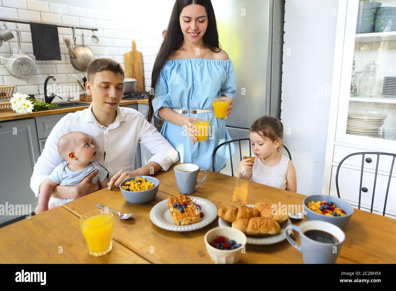Family having breakfast In the kitchen Stock Photo - Alamy