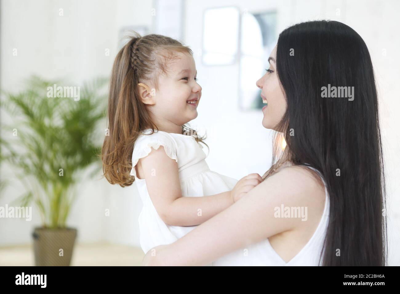 Happy young bright mother hugging her little daughter Stock Photo - Alamy