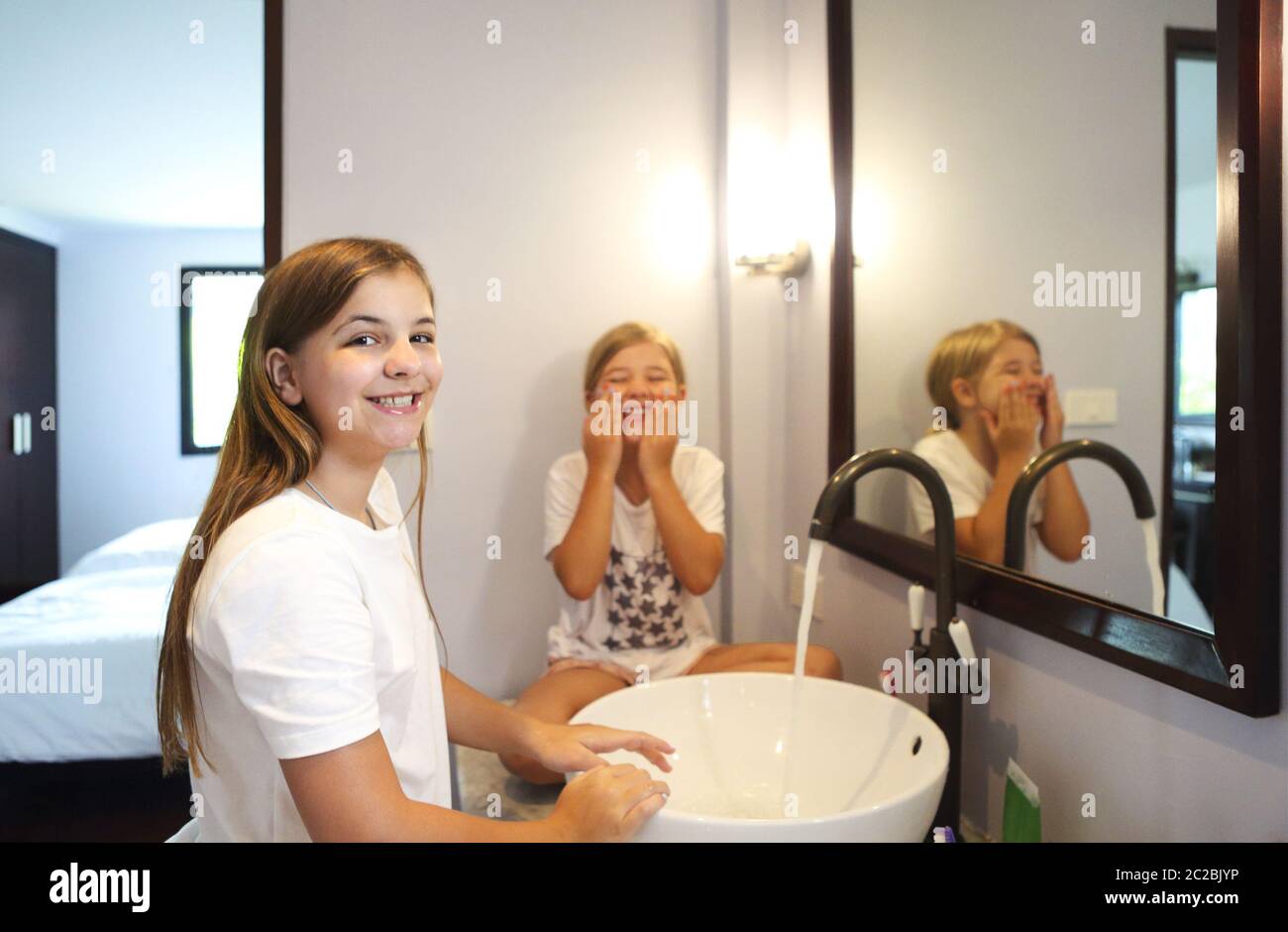 Happy children girls are washing their faces in a bathroom Stock Photo ...