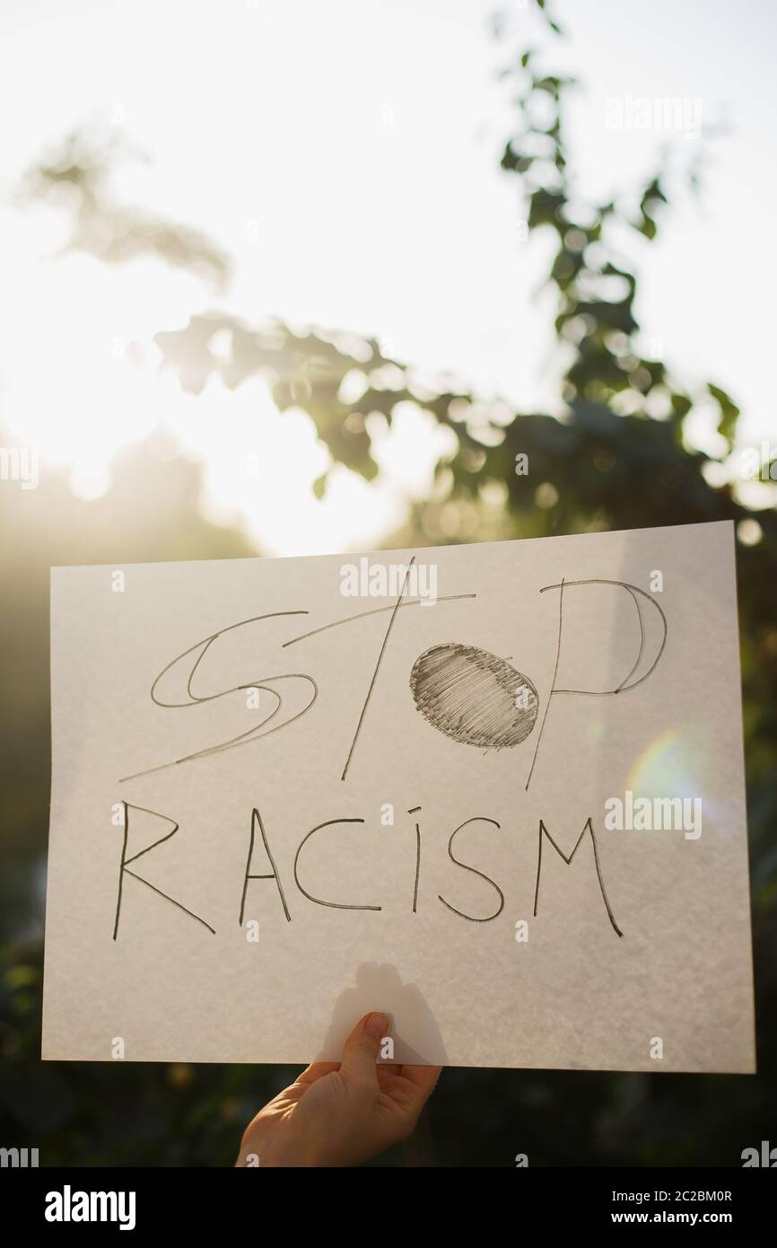Woman holding sign against racism hi-res stock photography and images ...