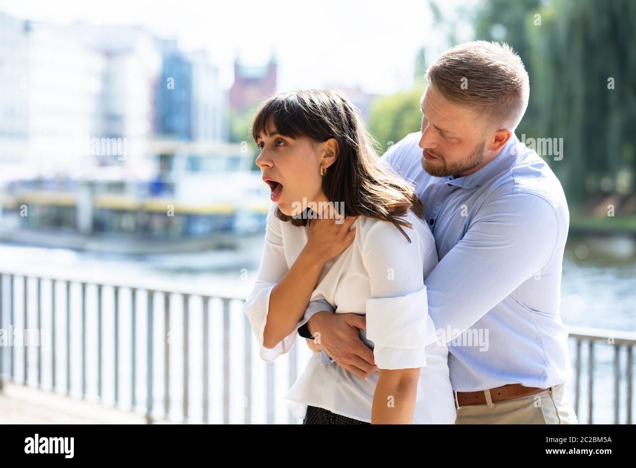 Man Helping Choking Woman To Expel A Trapped Object From Airway