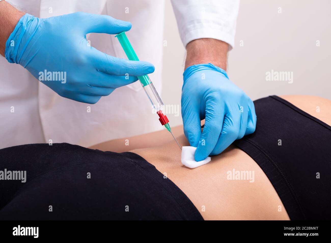 Doctor Giving Female Patient An Injection On Her Back In The Clinic ...