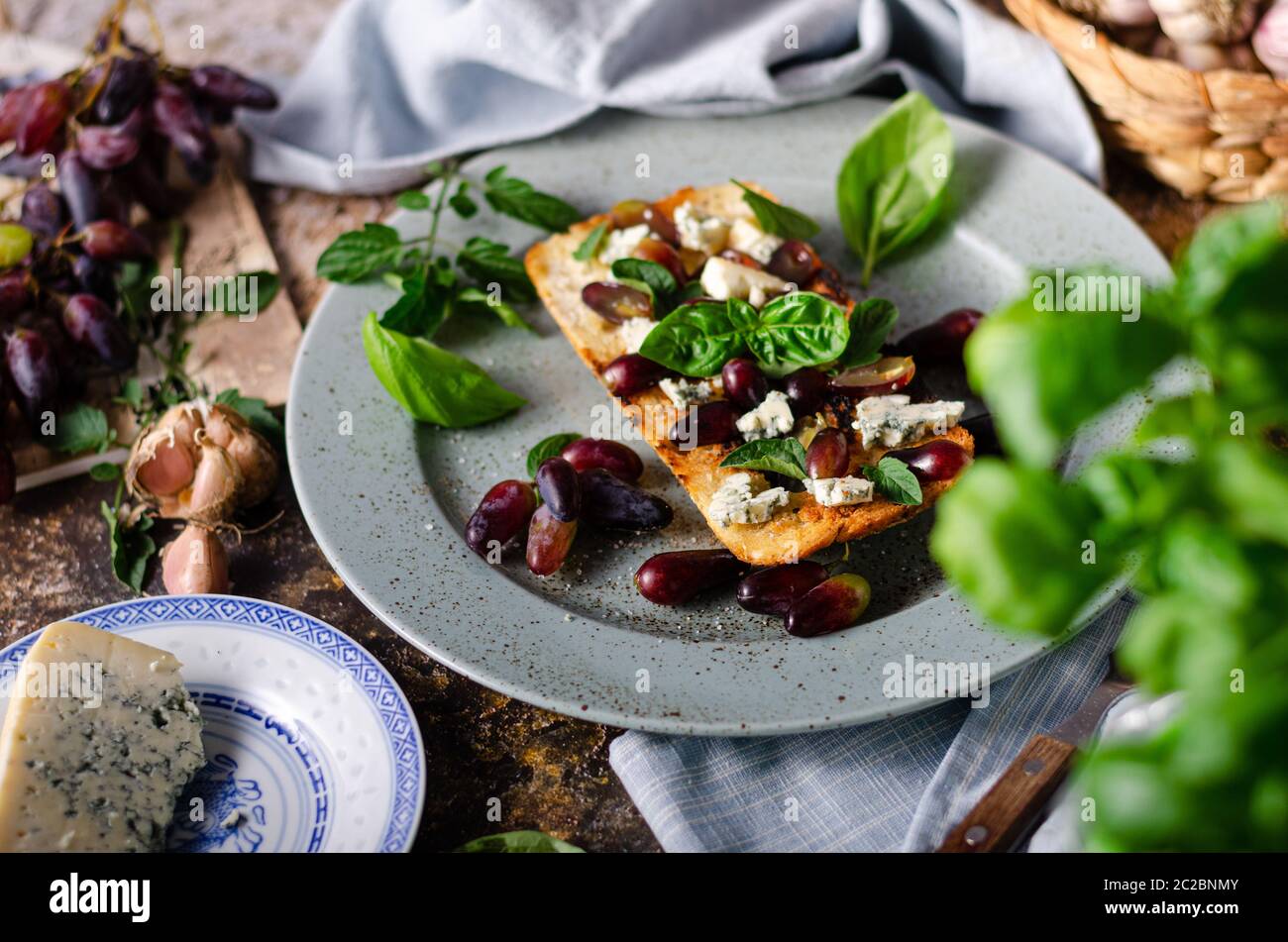 Morning breakfast with crispy bruschetta, blue cheese and grapes Stock ...