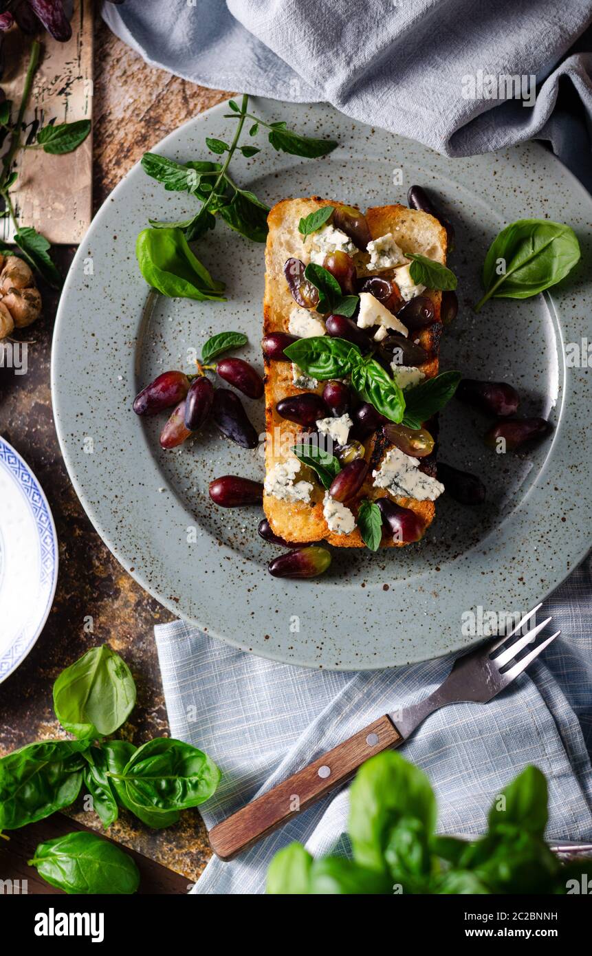 Morning breakfast with crispy bruschetta, blue cheese and grapes Stock ...