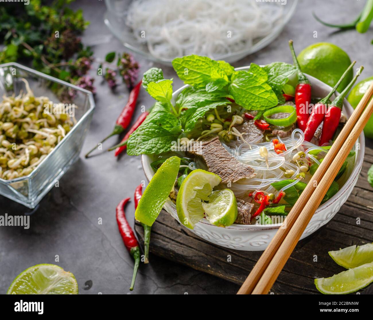 Traditional Vietnamese soup with chilli, noodles, fresh herbs and beef ...