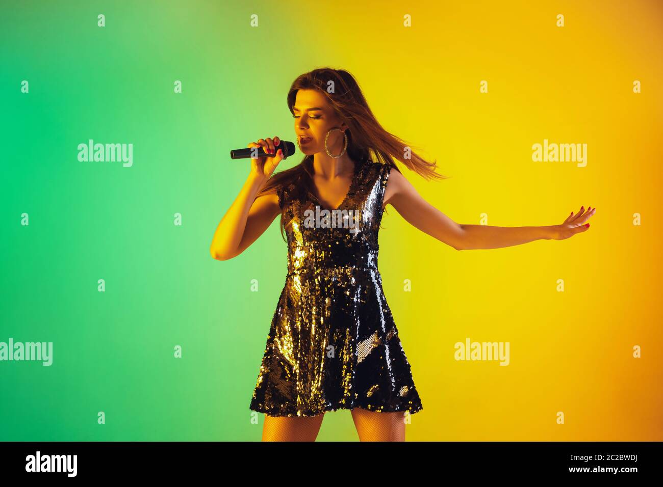 Caucasian female singer portrait isolated on gradient studio background ...