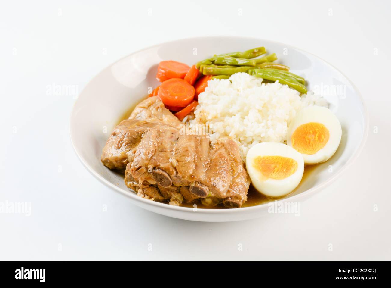 Baked pork ribs with rice, boiled egg and vegetable Stock Photo - Alamy